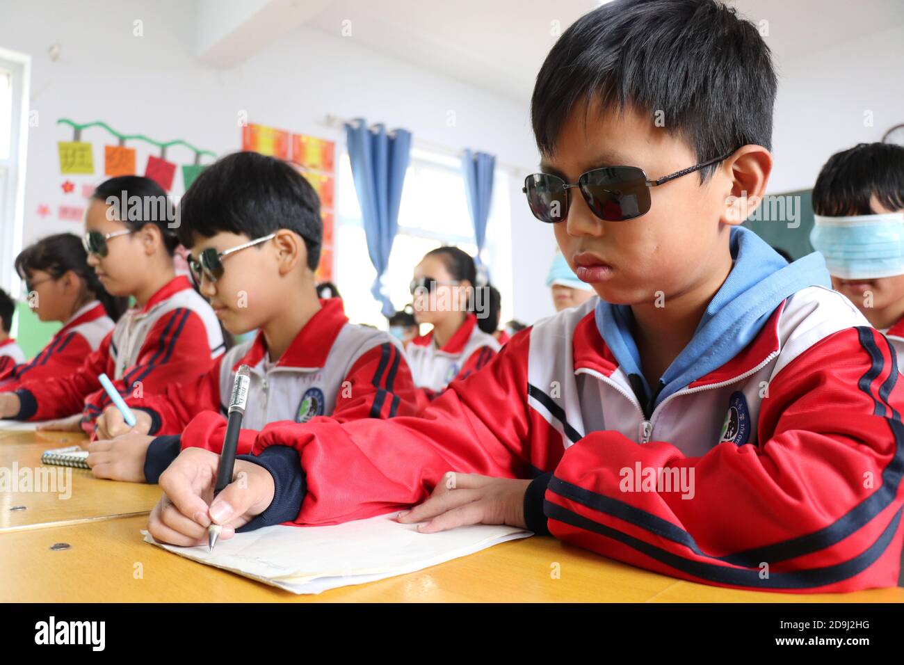 Primary students with blindfold on experience daily life of the blind ...