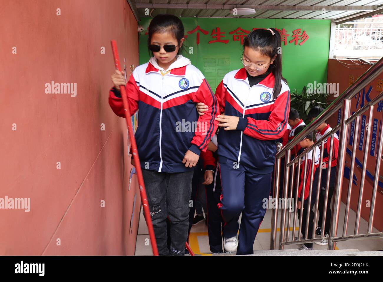 Primary students with blindfold on experience daily life of the blind ...