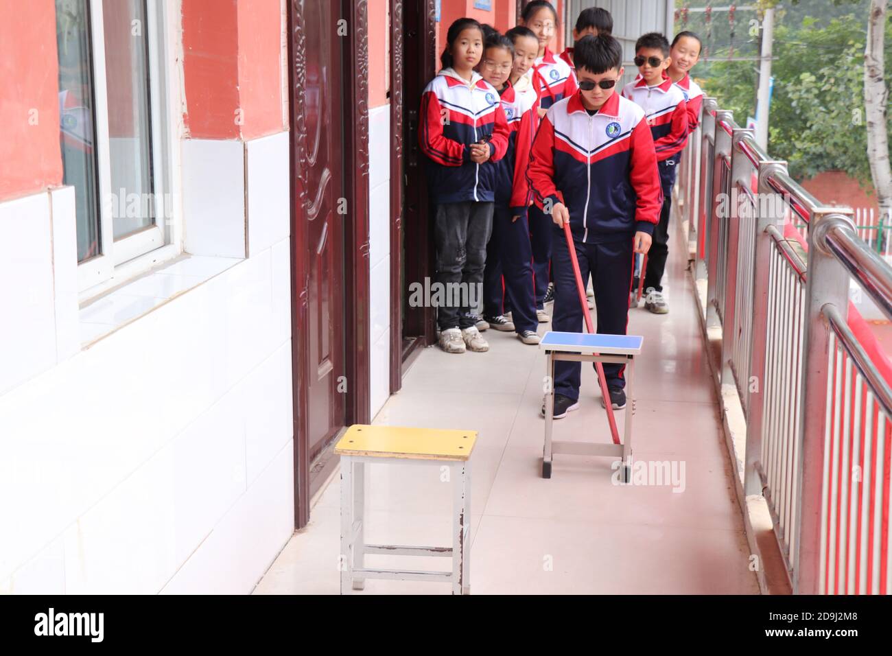 Primary students with blindfold on experience daily life of the blind ...