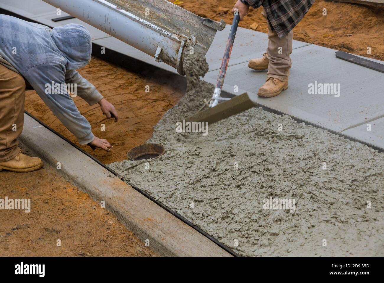 Pouring cement during on concrete new sidewalk Stock Photo - Alamy
