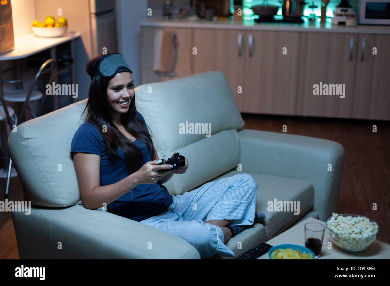 Gamer using joystick playing video games on console sitting on couch in ...