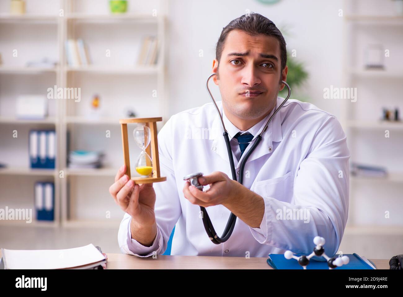 Young doctor in time management concept Stock Photo - Alamy