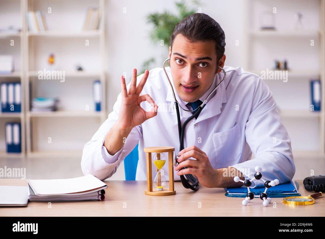 Young doctor in time management concept Stock Photo - Alamy