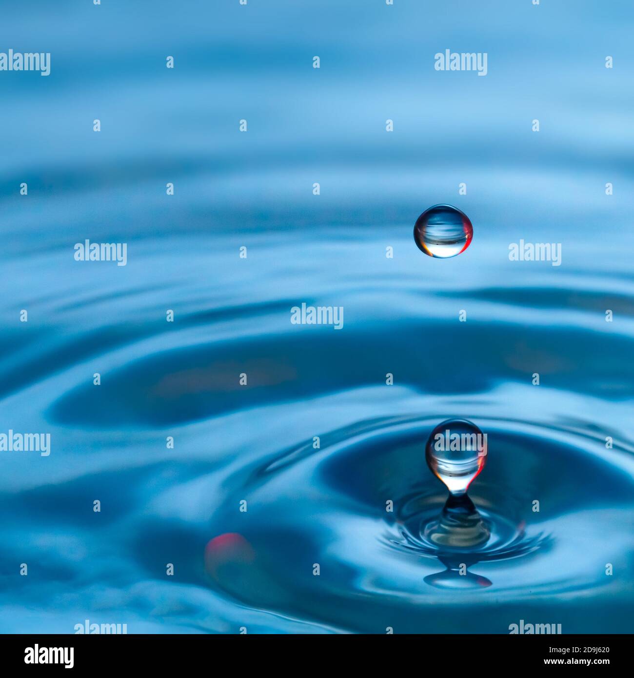 Blue Water drop splash with red tones Stock Photo - Alamy