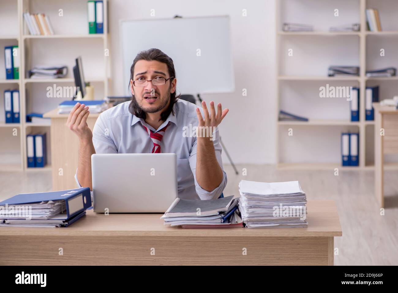 Male employee unhappy with excessive work Stock Photo - Alamy