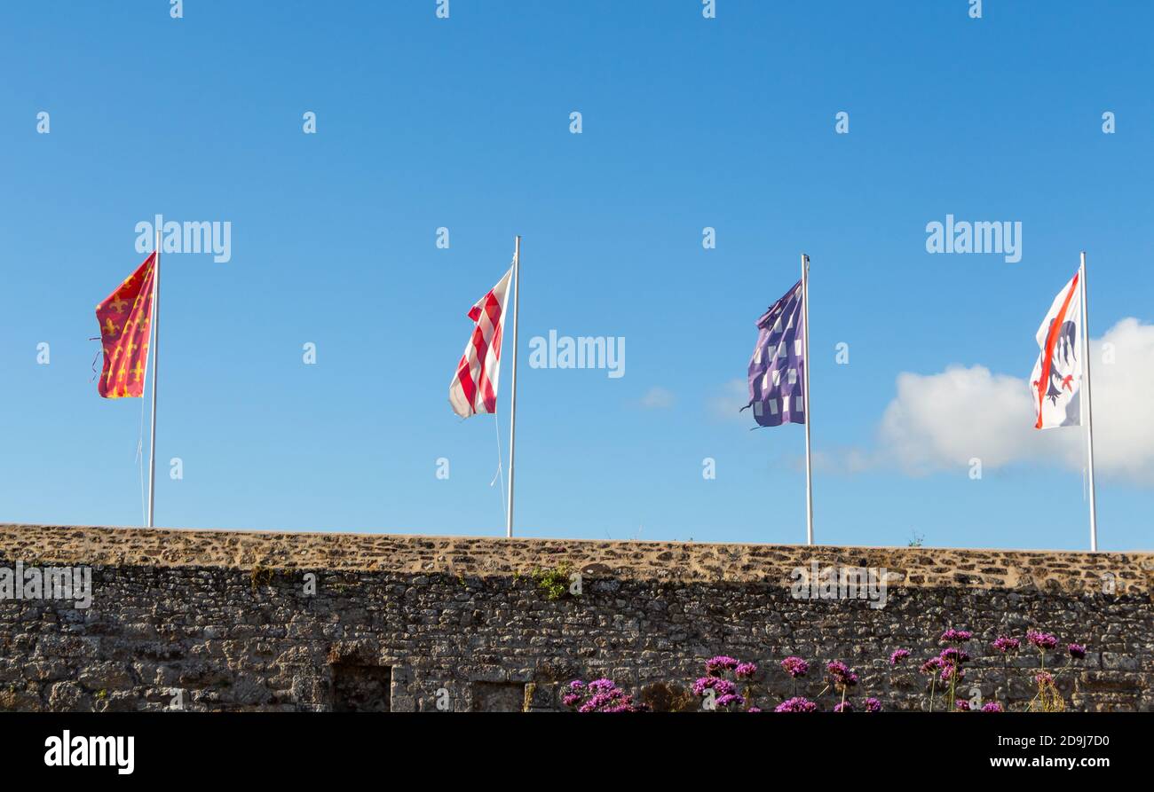 Flags with different emblems on a wall of Dinan castle Stock Photo - Alamy