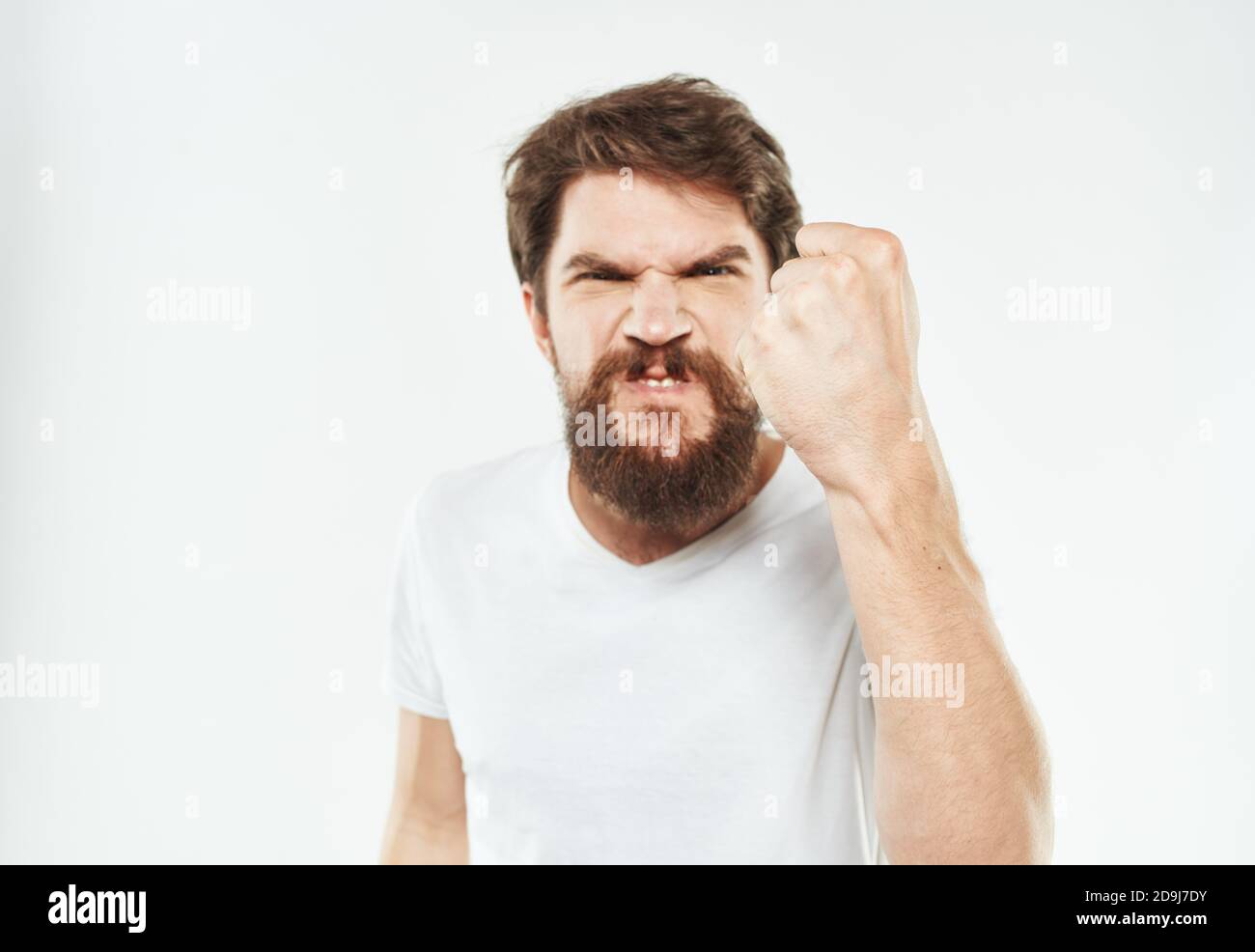 Aggressive man gestures with his hands on a light background and a ...
