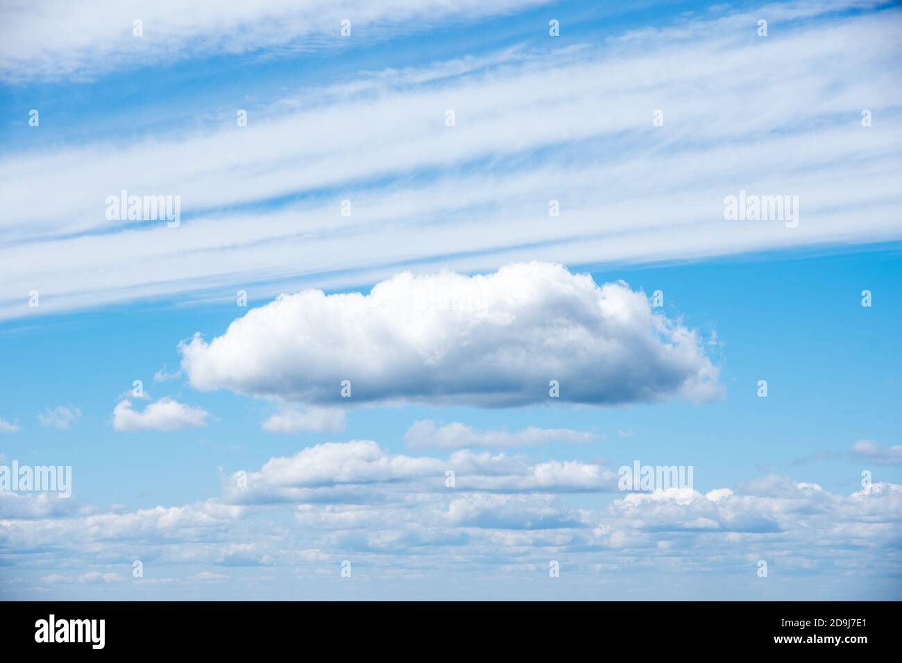 A huge cumulus cloud and many small clouds on a blue sky. Nature ...