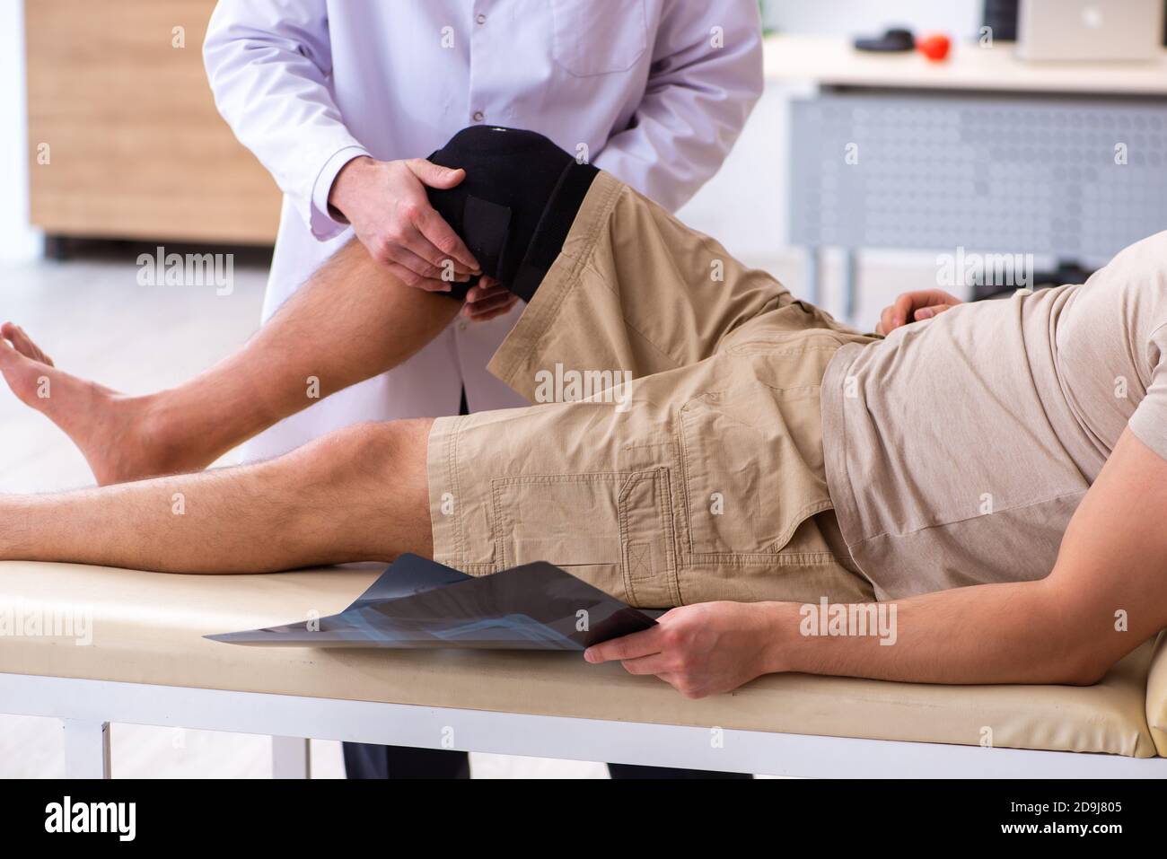 Young man visiting experienced doctor in hospital Stock Photo - Alamy
