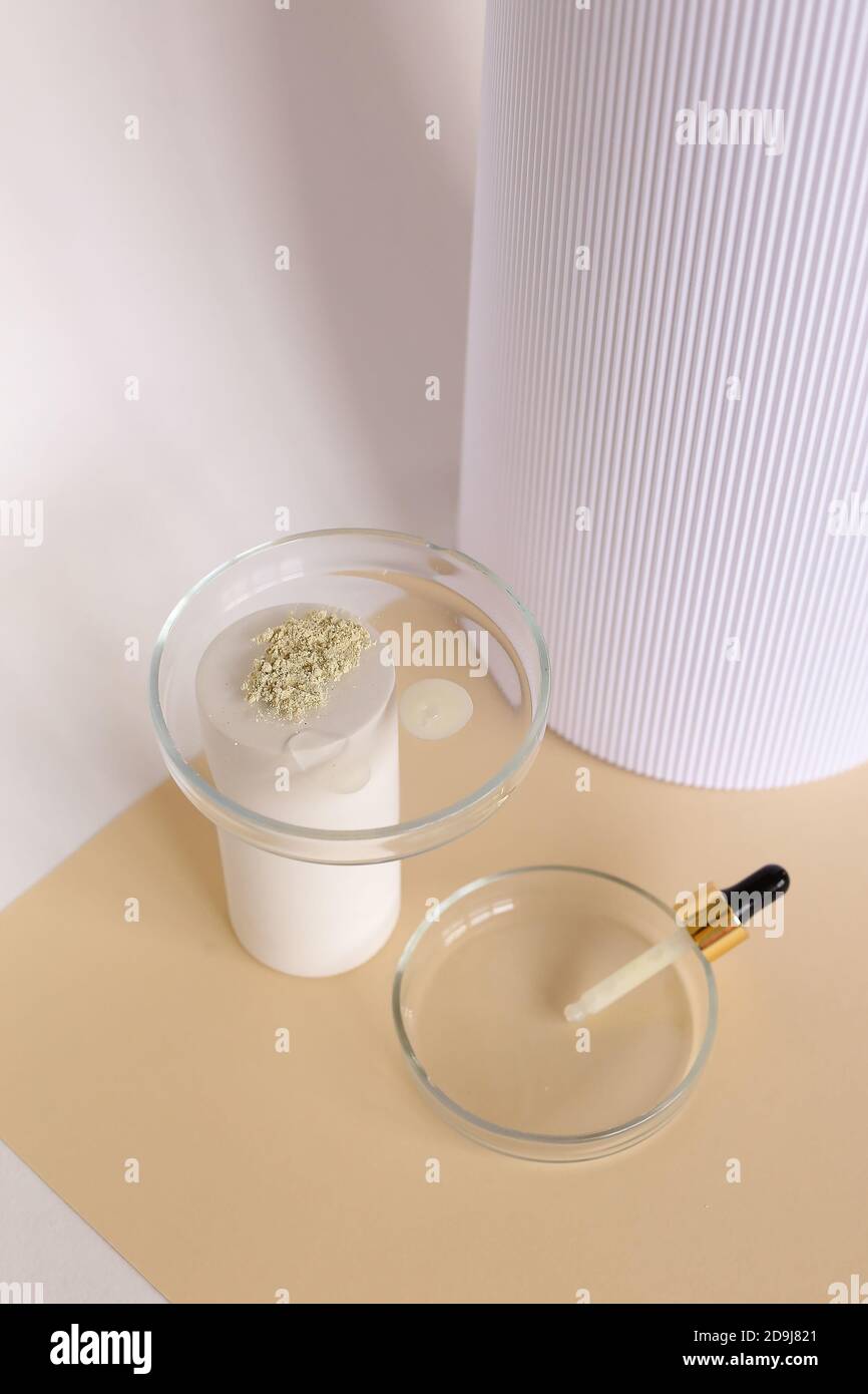 Clay powder and water in glass jar near pipette on beige background ...