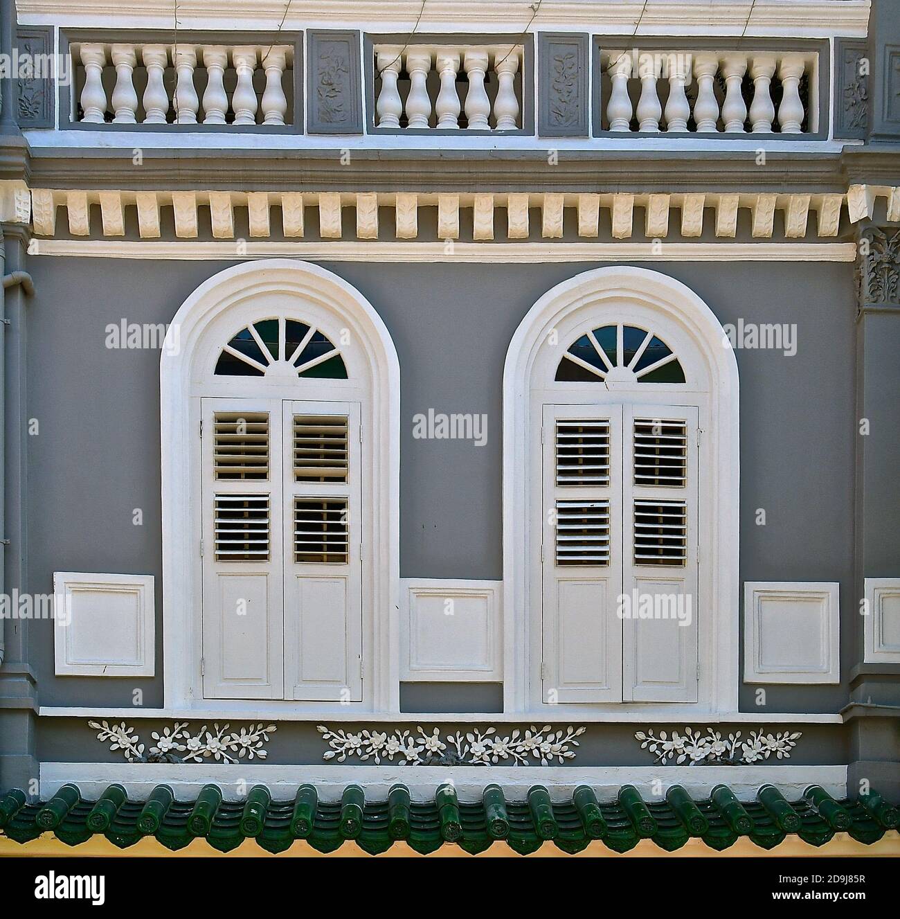 Restored grey traditional peranakan building with two ornate white ...