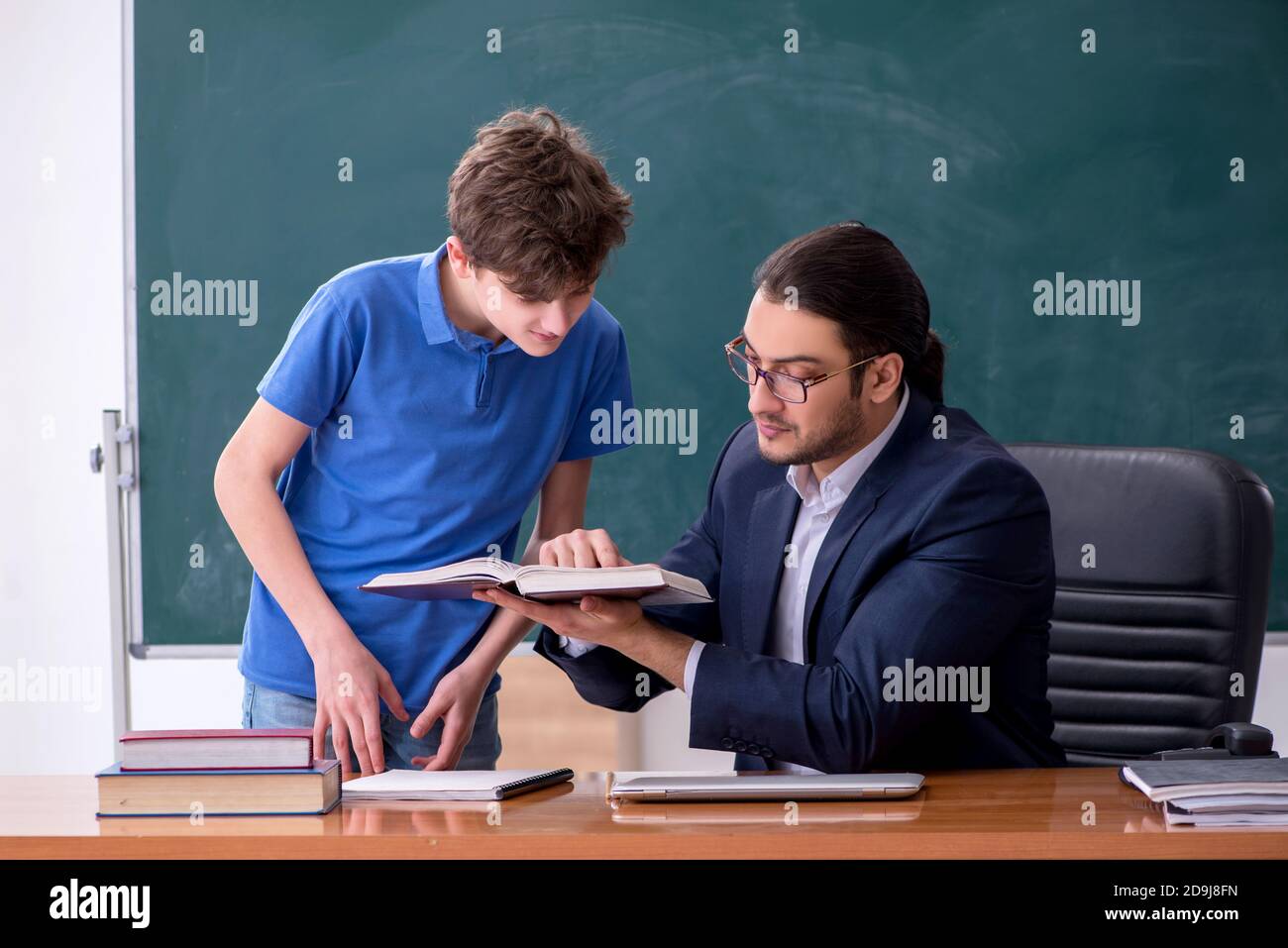 Male teacher and schoolboy in the classroom Stock Photo - Alamy
