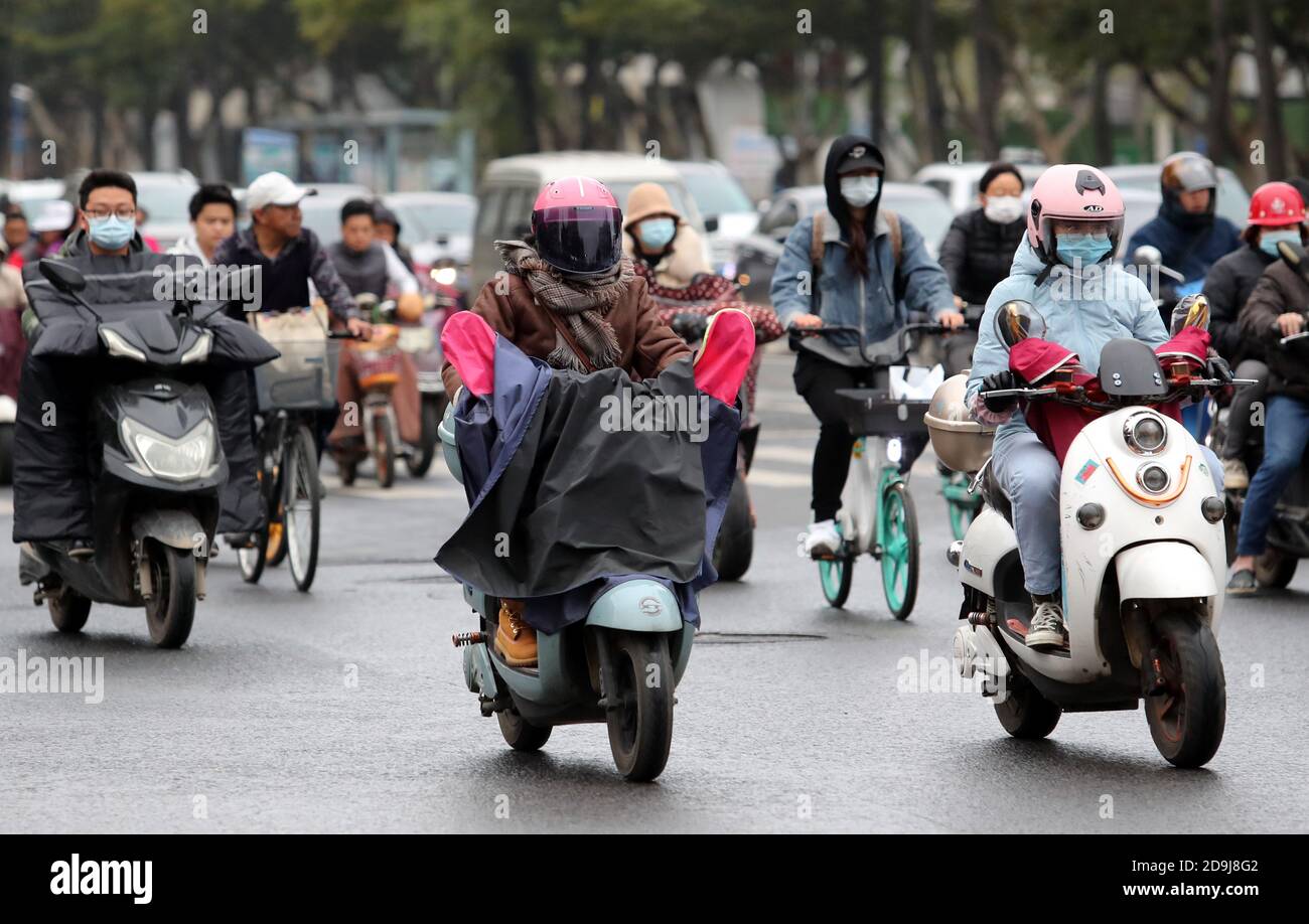 People wear thick clothes and hats while riding on the road because of ...