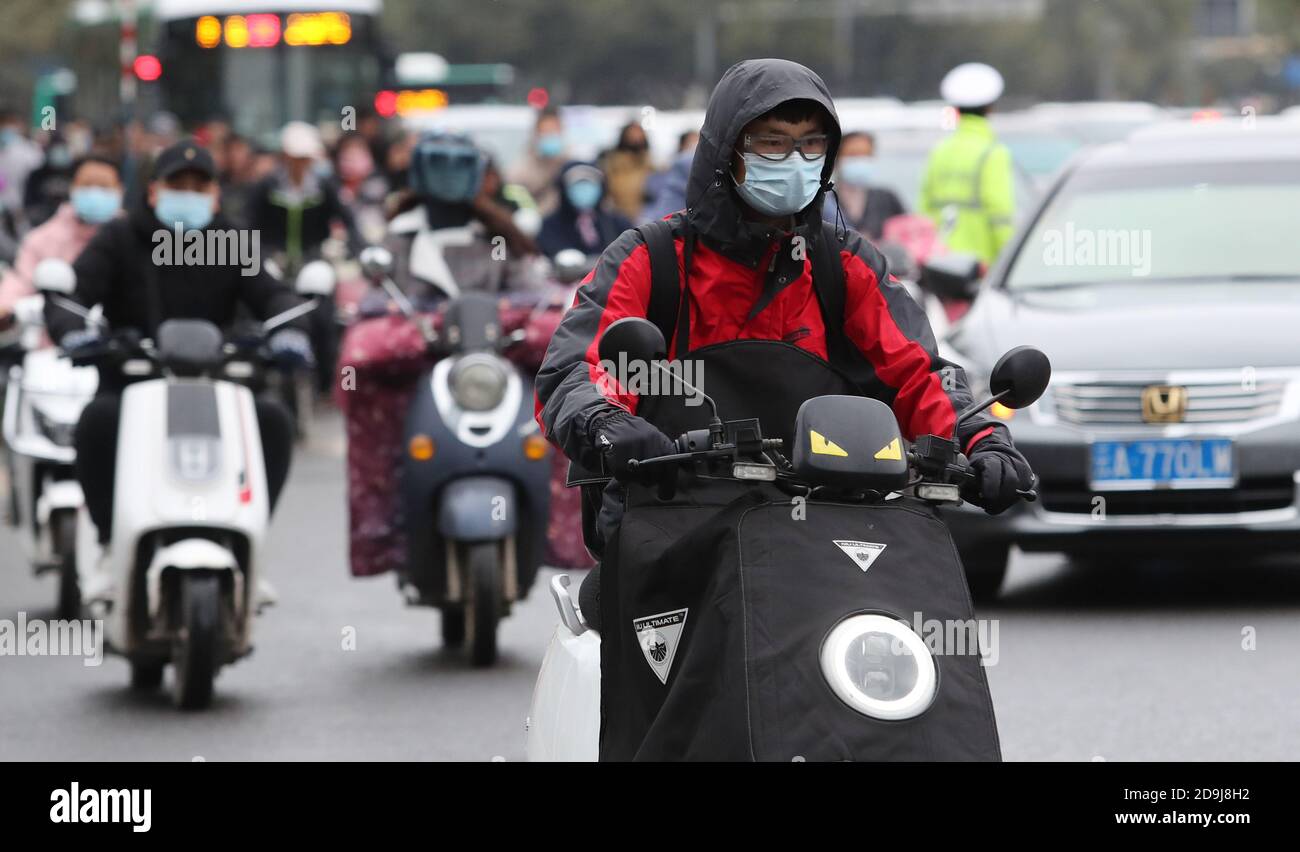 People wear thick clothes and hats while riding on the road because of ...