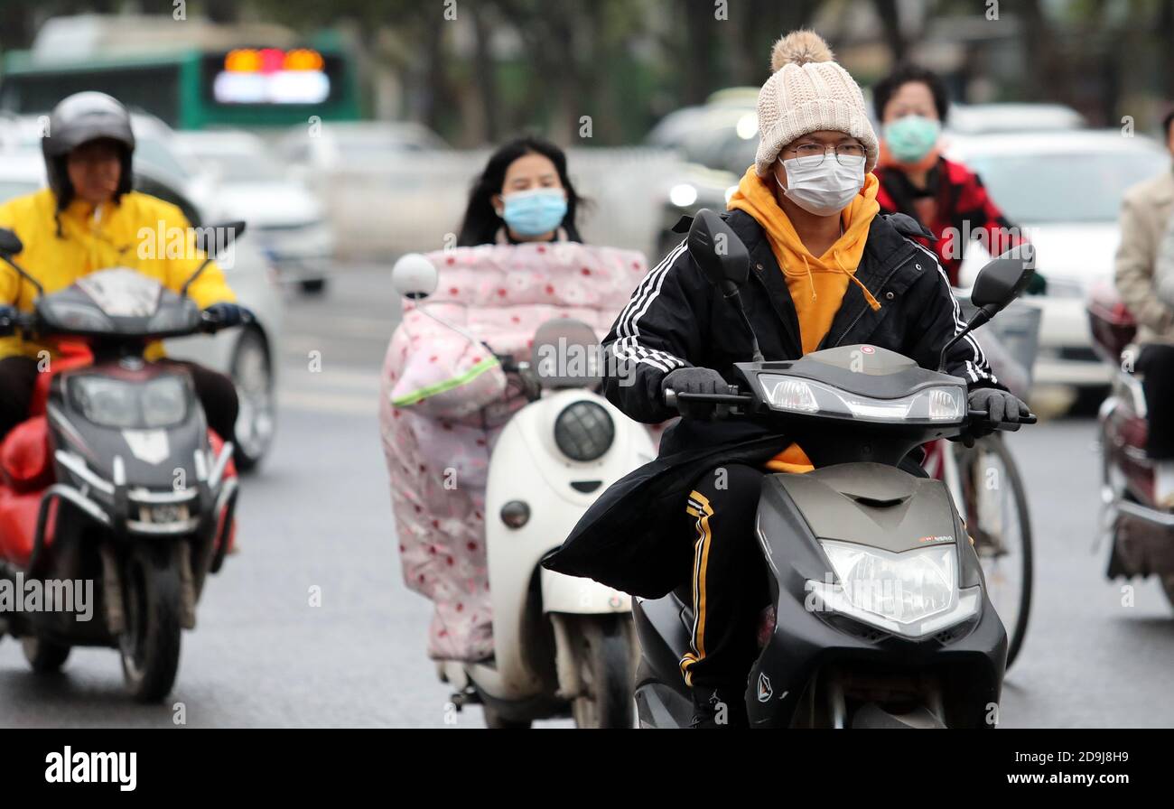 People wear thick clothes and hats while riding on the road because of ...