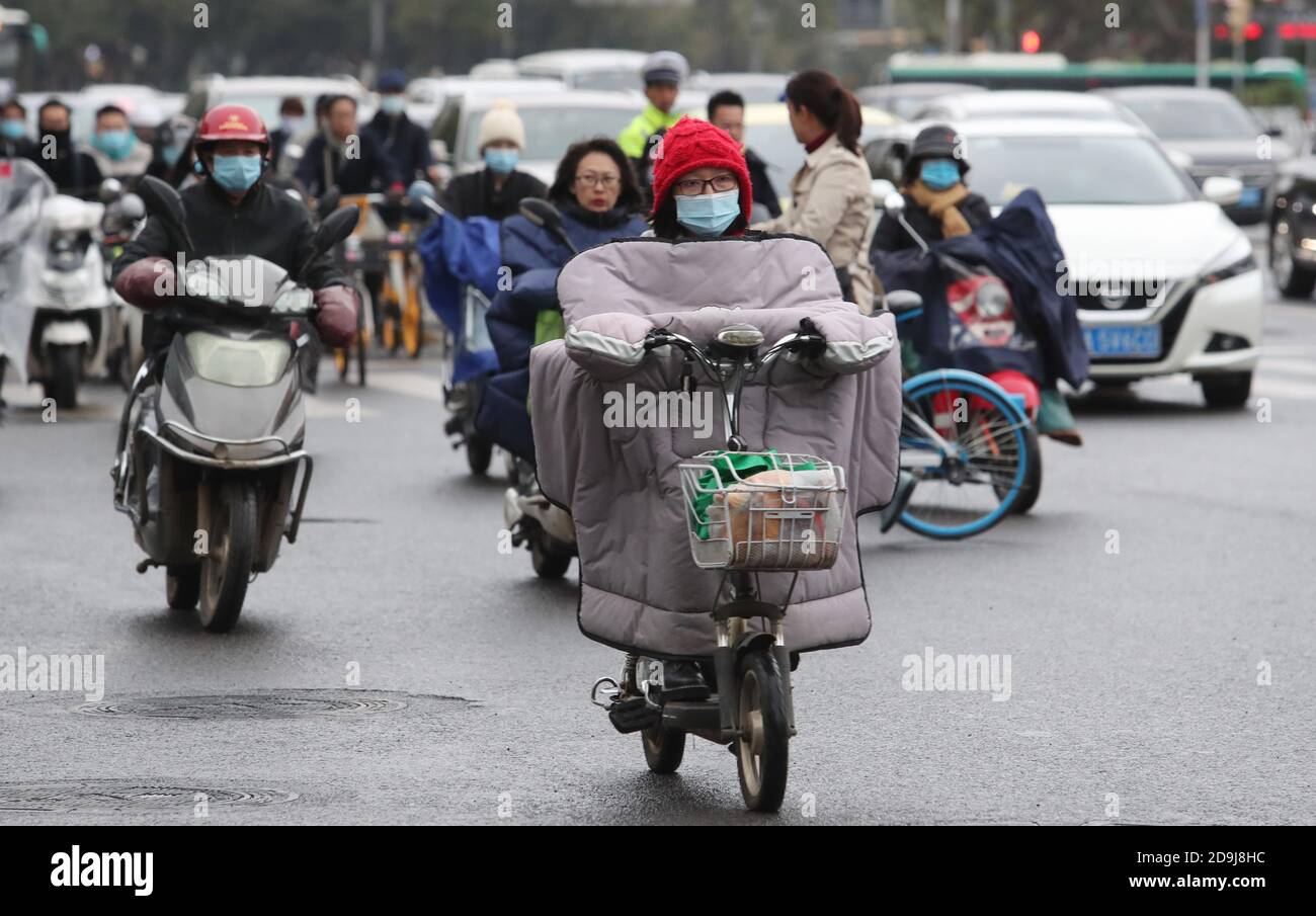 People wear thick clothes and hats while riding on the road because of ...