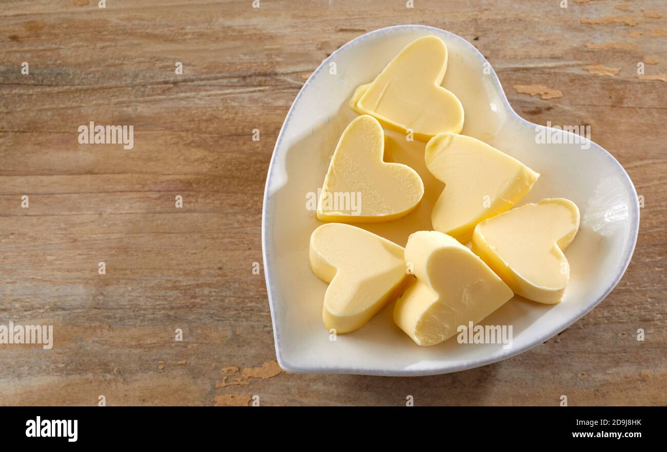 Heart shaped butter pats symbolic of love in a matching white dish on a ...