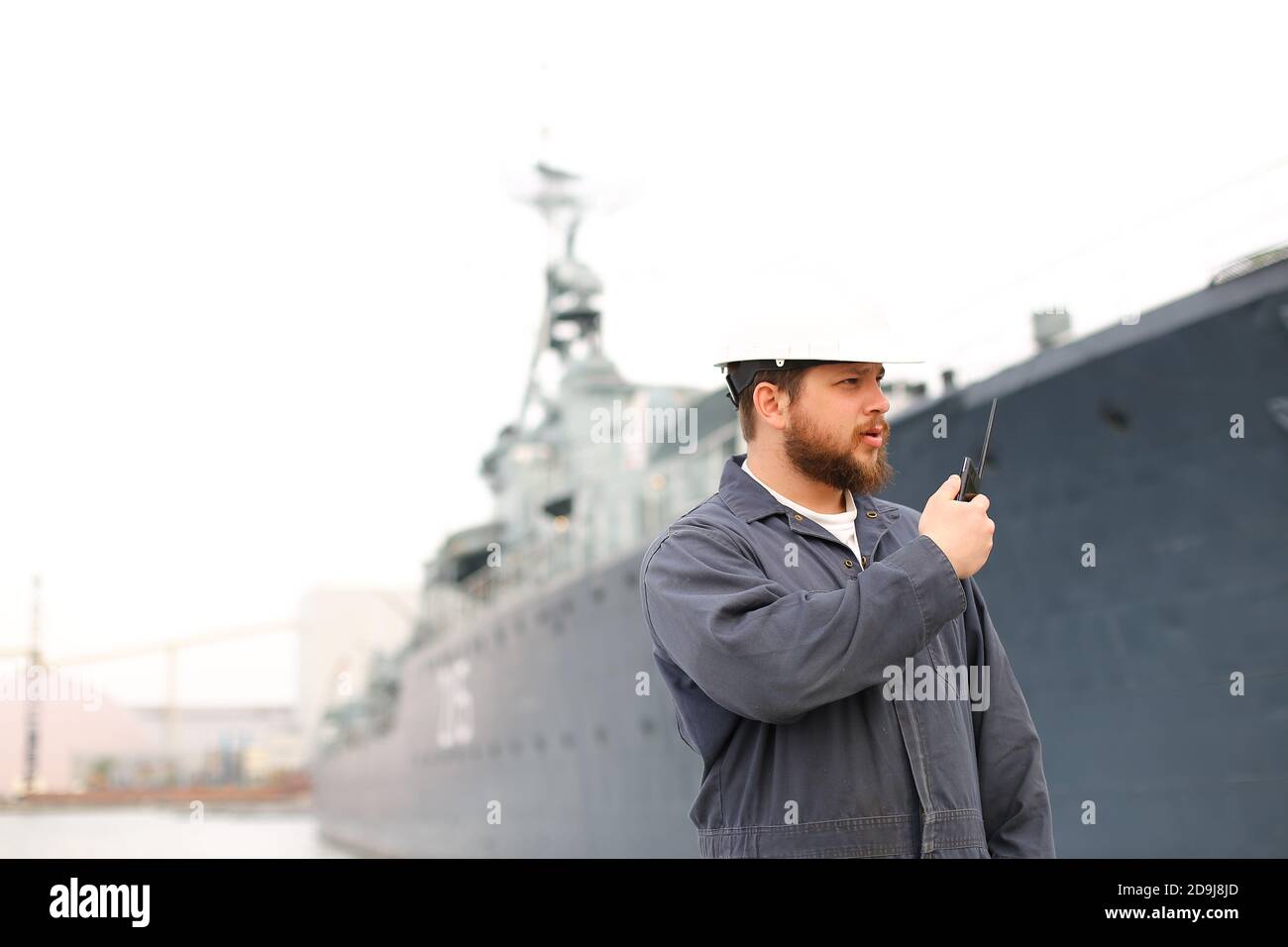 Marine captain talking by walkie talkie radio and standing near ...