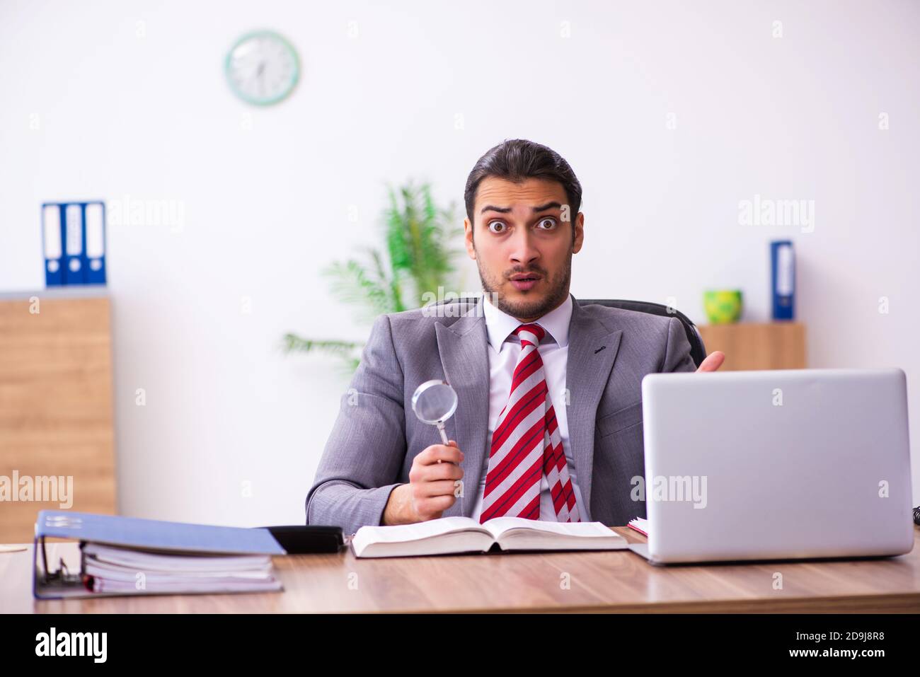 Male employee reading book in the office Stock Photo - Alamy