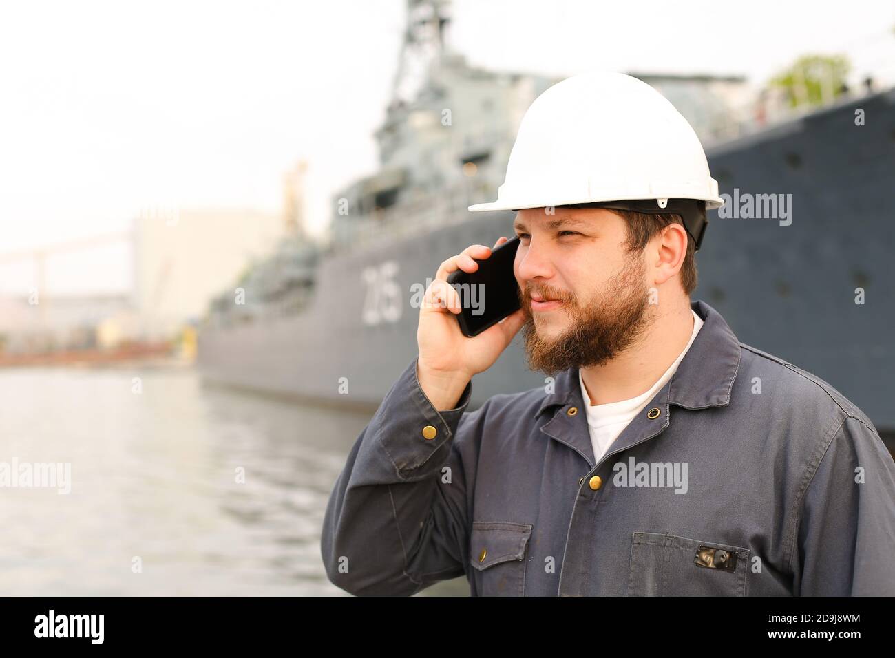 Marine male engineer talking by VHF walkie talkie near vessel in ...