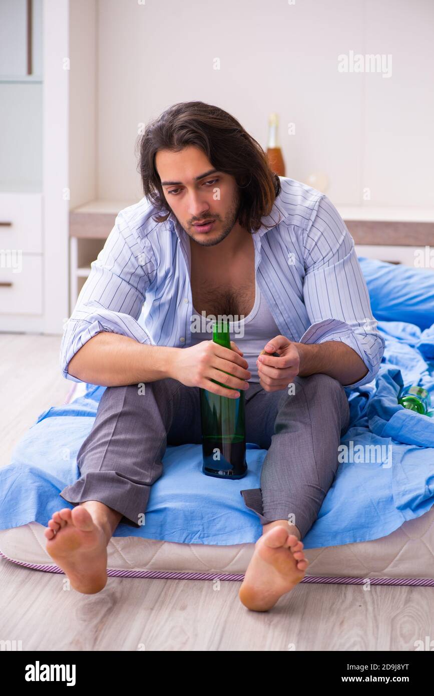 Male alcoholic in the bedroom Stock Photo - Alamy