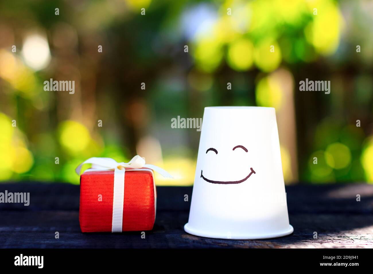 White disposable cup with happiness emotion and red gift. Emotion of ...