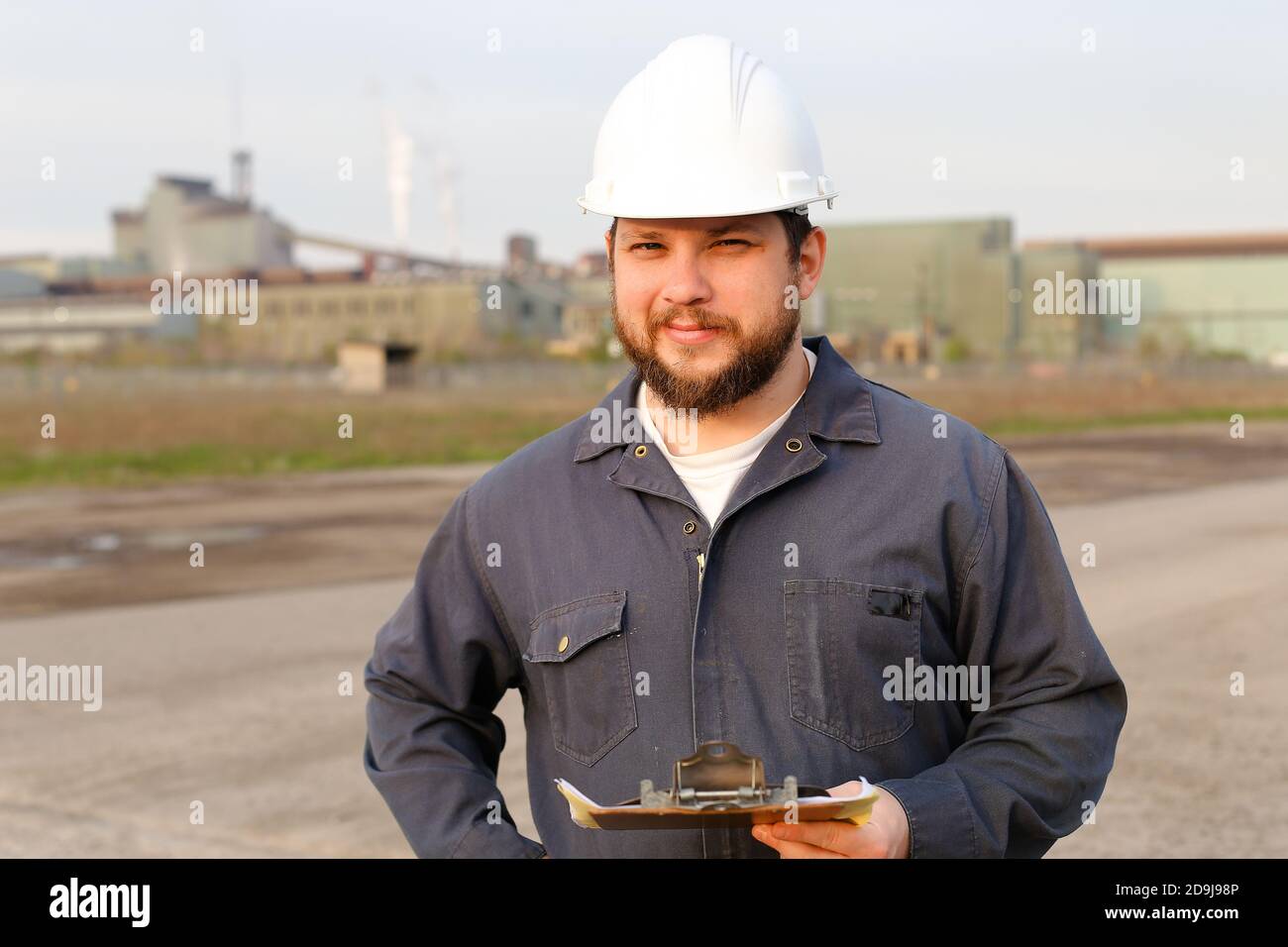 Portrait of industrial engineer standing on construction site and ...