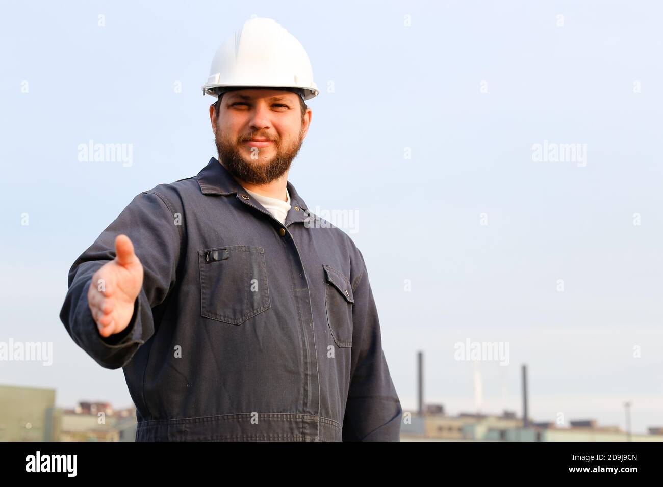 Portrait of european foreman with outstetched hands standing in ...