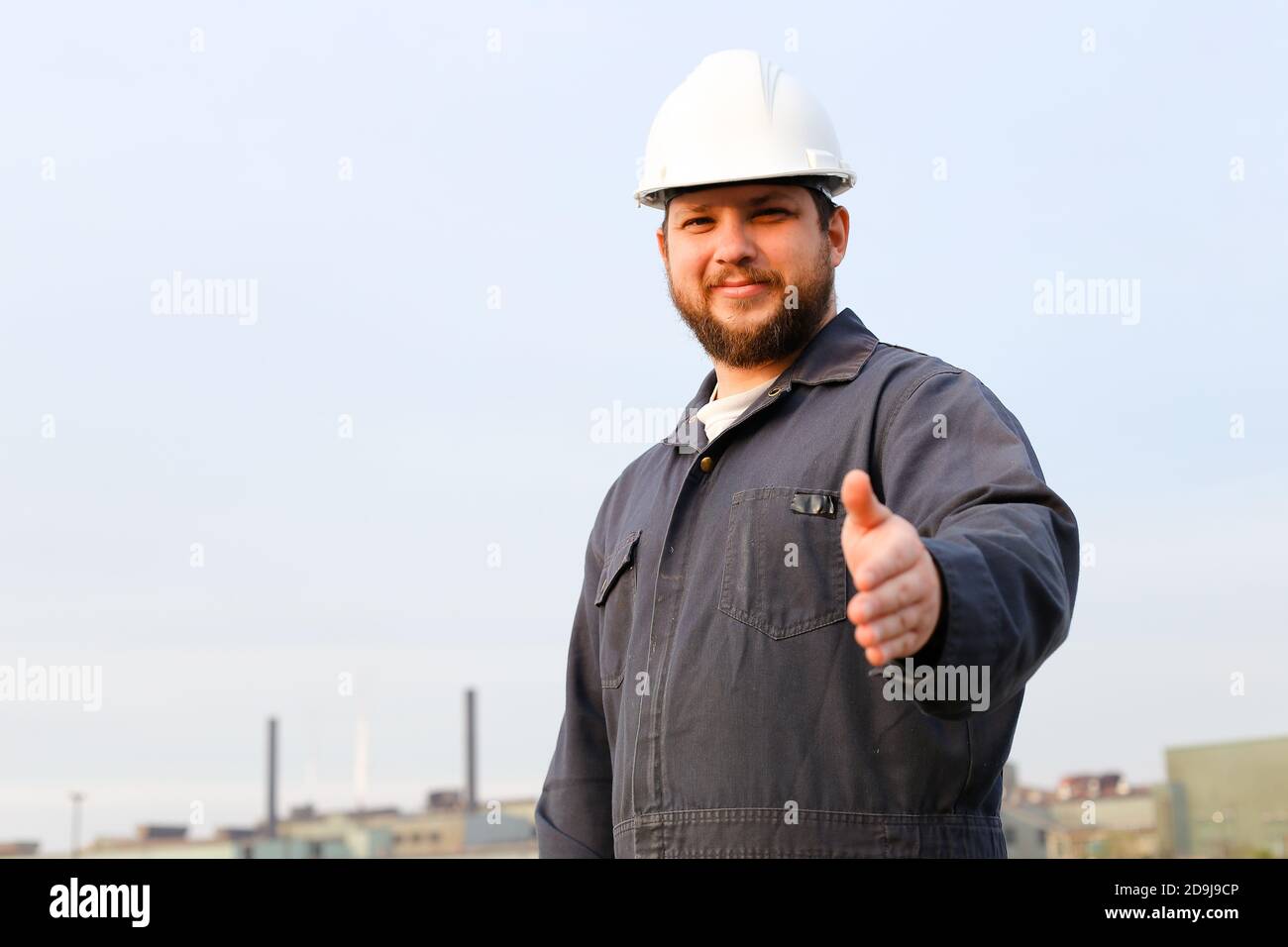 Portrait of male foreman with outstetched hands standing in ...