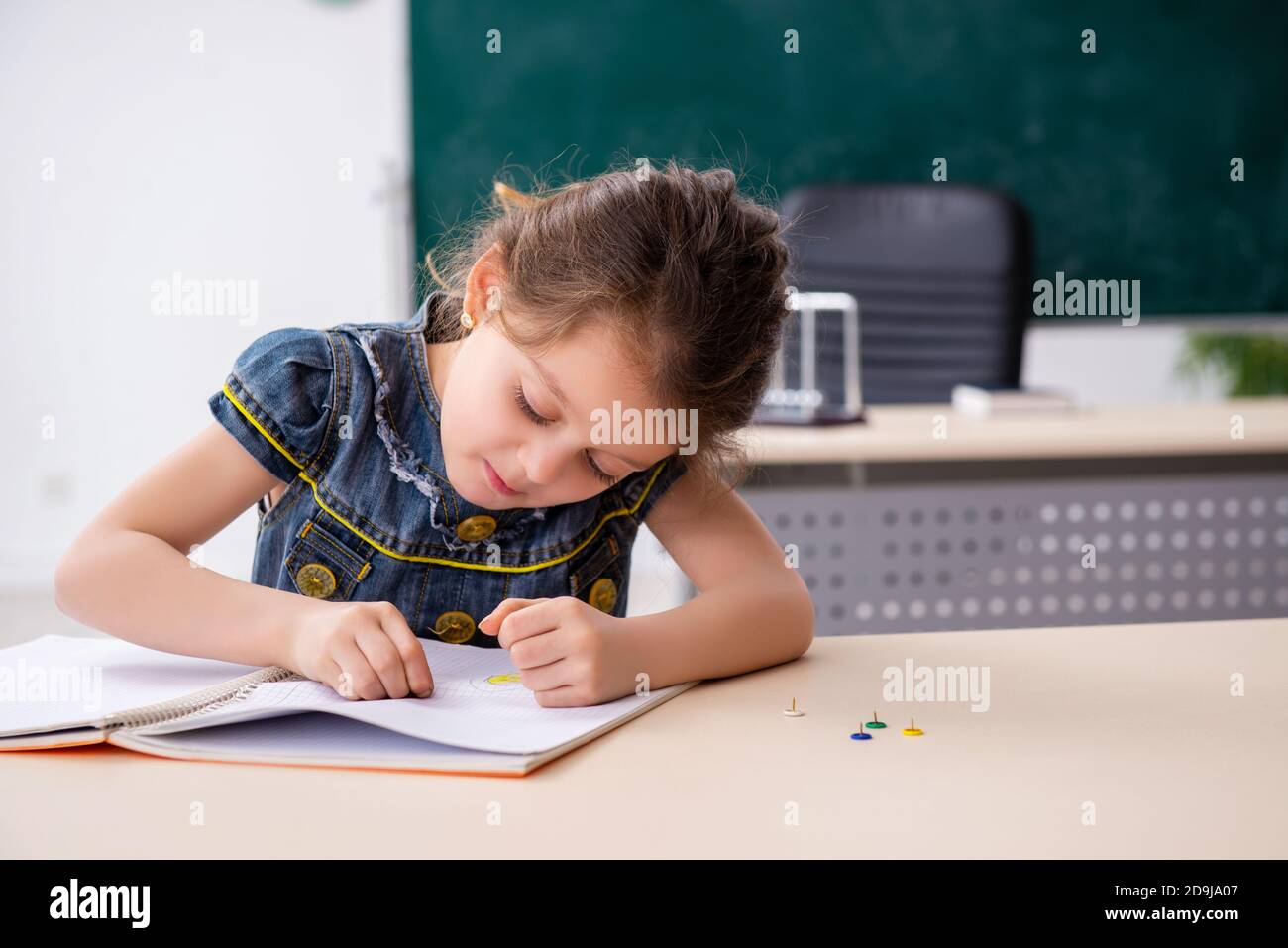 Little girl and thumbtacks in the classroom Stock Photo - Alamy