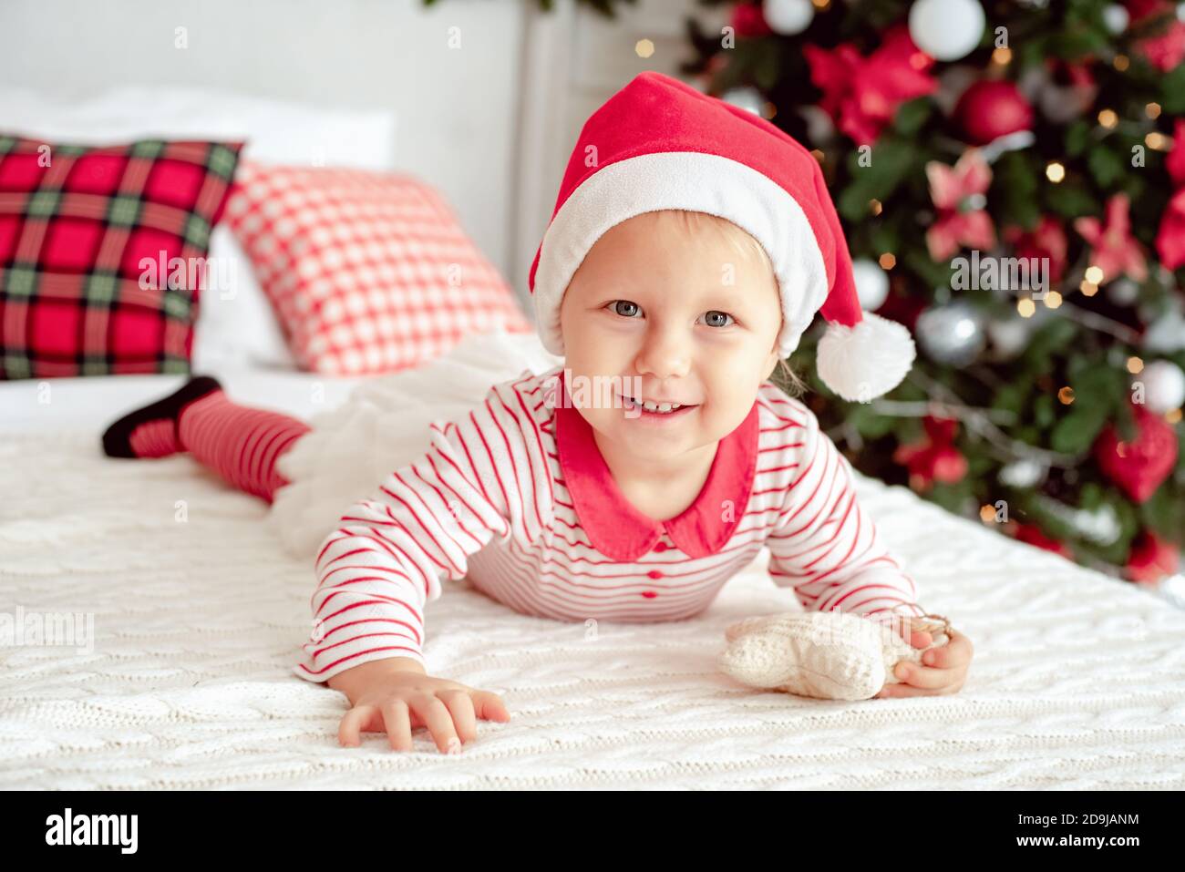 little girl under Christmas tree. Cute Christmas Child in Santa Hat ...