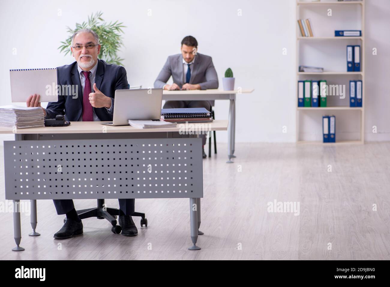 Old boss and his assistant working in the office Stock Photo - Alamy