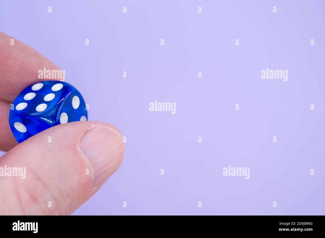 Closeup shoat of a hand holding blue dice isolated on white background ...