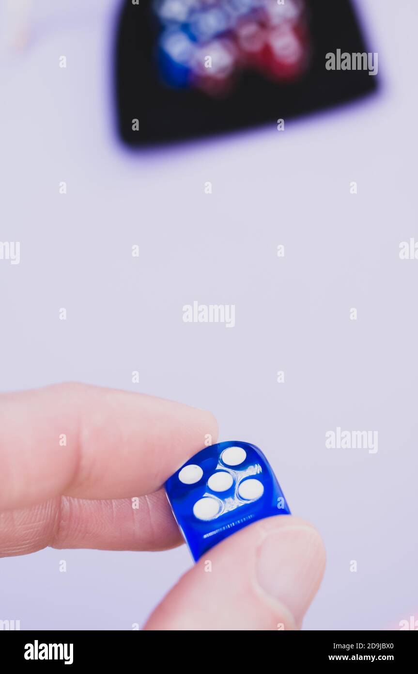 Vertical shoat of a hand holding blue dice isolated on white background ...