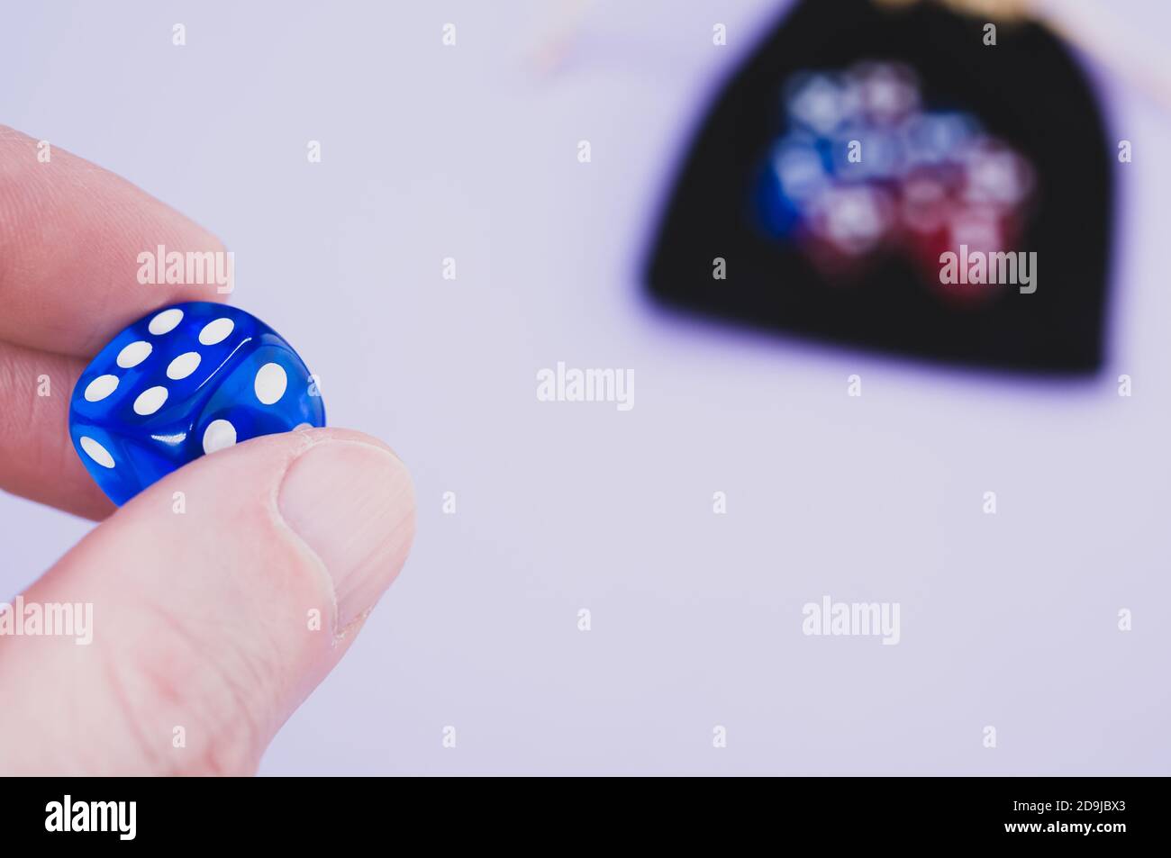 Closeup shoat of a hand holding blue dice isolated on white background ...