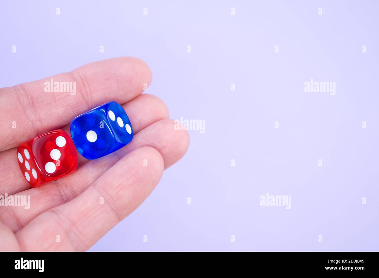 Closeup shot of a hand holding red and blue dice isolated on white ...
