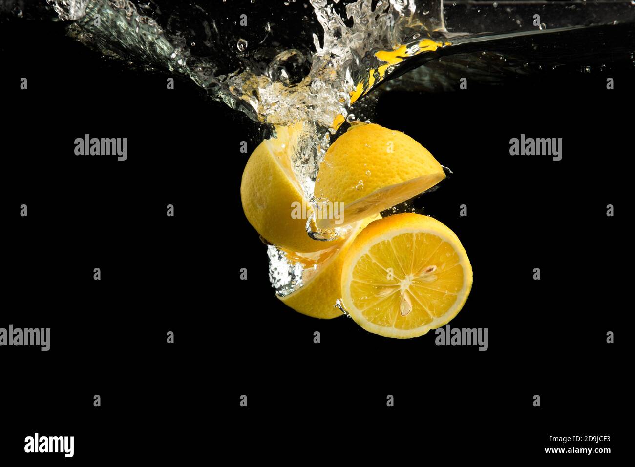 Fresh yellow lemons in water splash on black background Stock Photo - Alamy