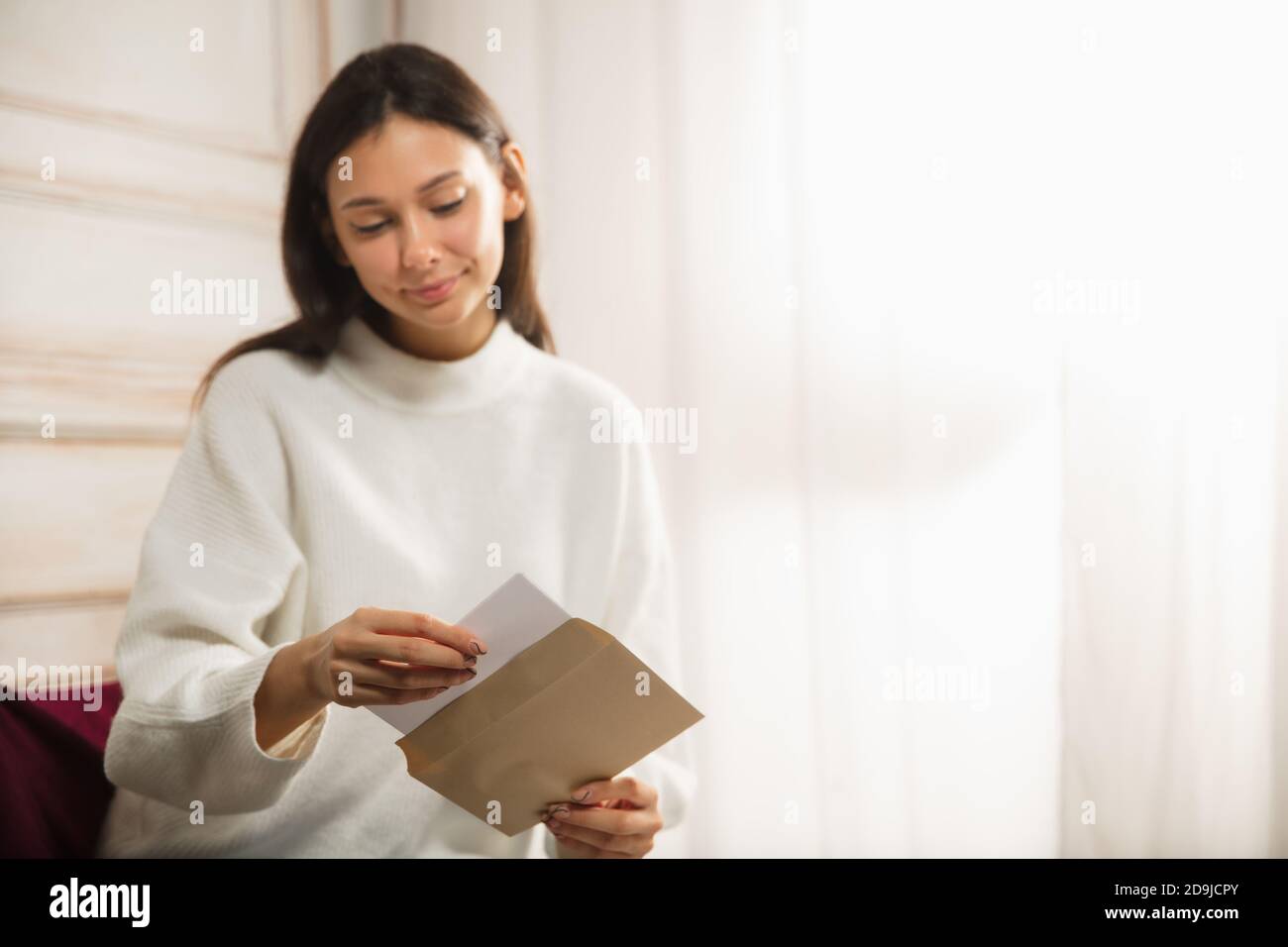 Woman opening, recieving greeting card for New Year and Christmas 2021 ...
