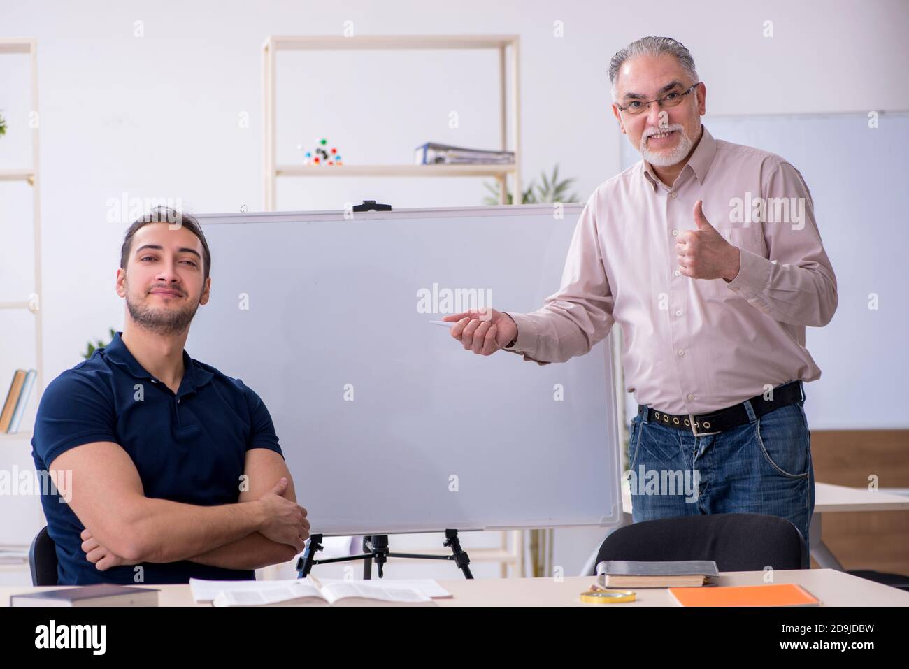 Old teacher and young student in the classroom Stock Photo - Alamy