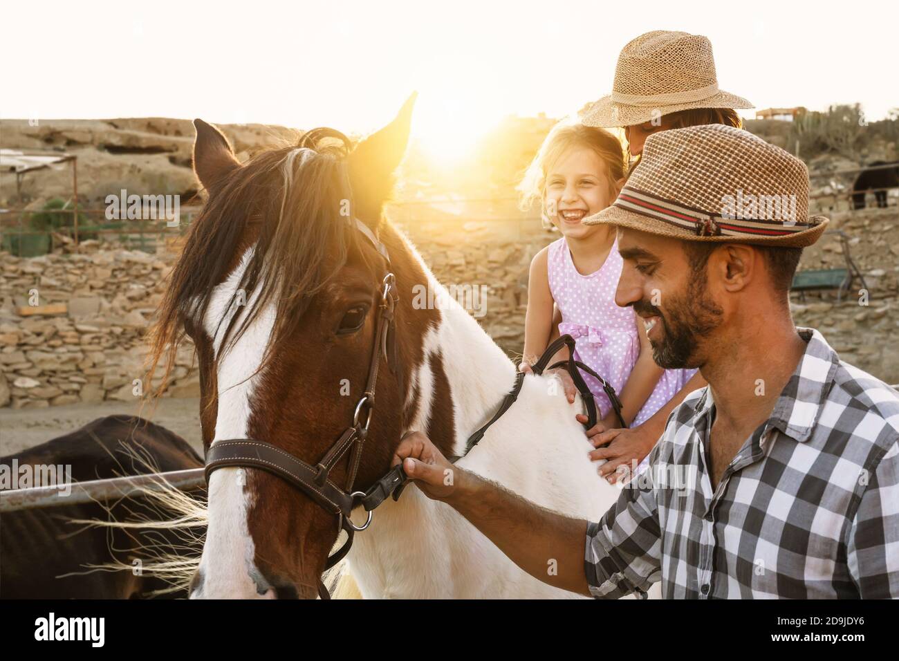 Happy family having fun riding on horse inside ranch Stock Photo - Alamy