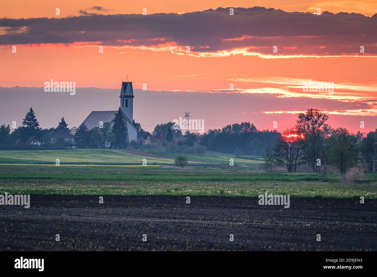Shot of a fantastic sunset over a village with a white tower Stock ...