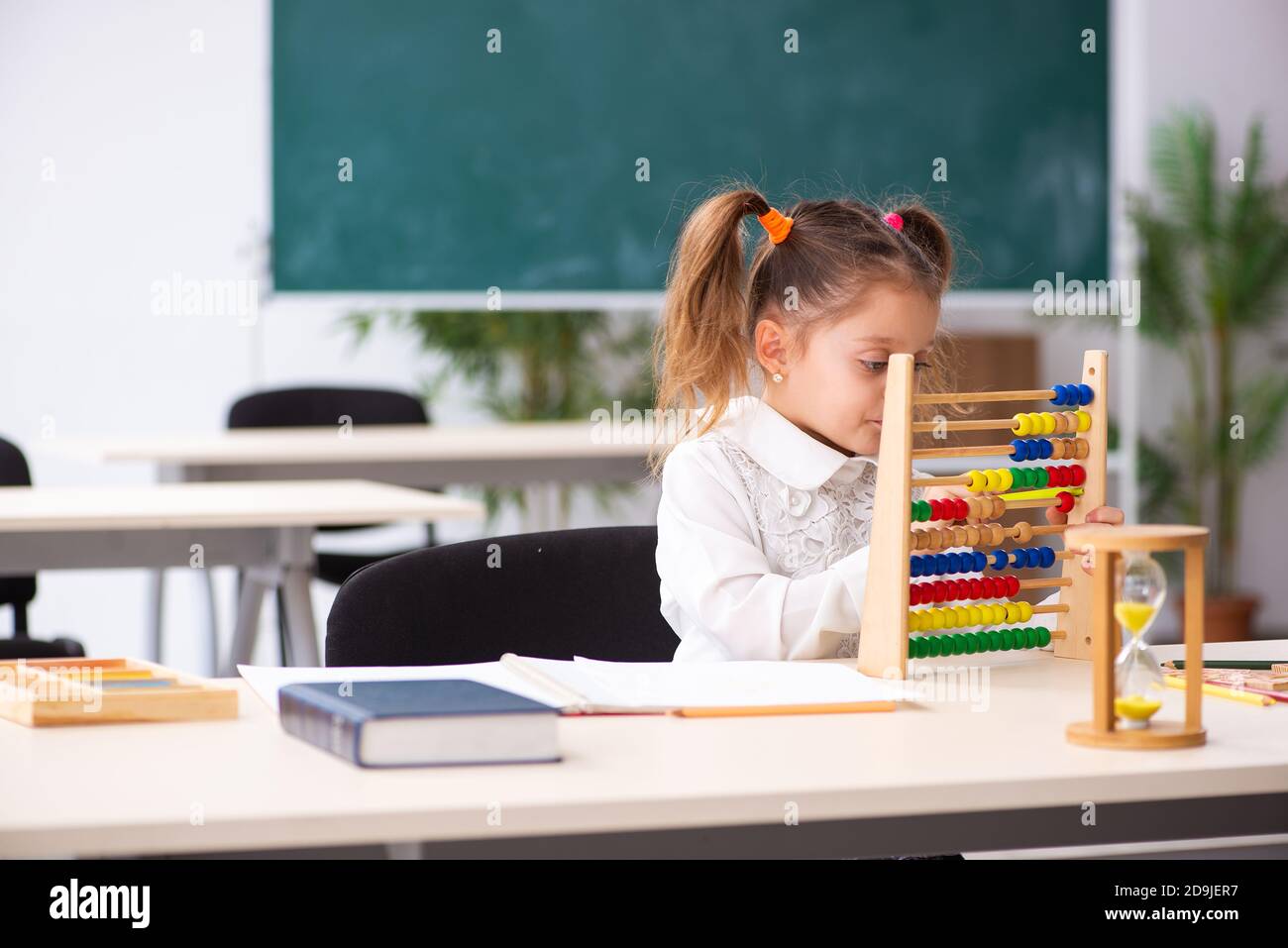 Small girl with the abacus in the classroom Stock Photo - Alamy
