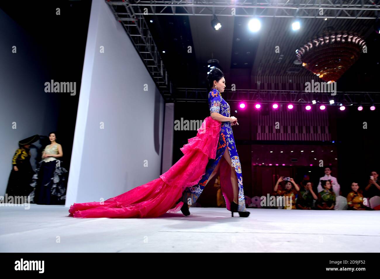 A model dresses in traditional Chinese clothes, walking on a T runway ...