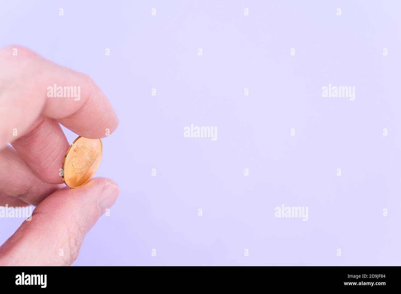 Closeup shot of a hand holding gold coin isolated on white background ...