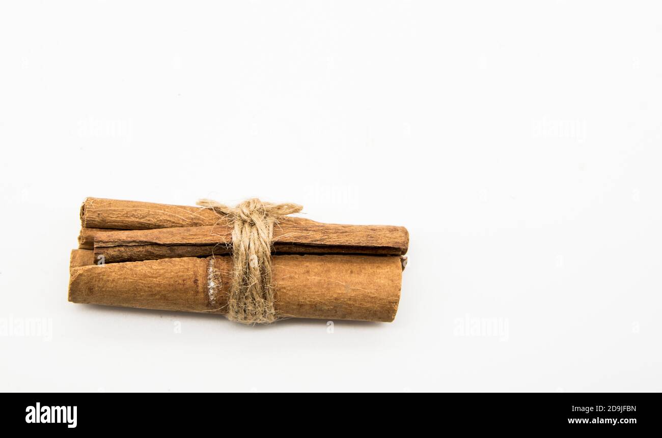 Cinnamon sticks tied with a cord on a white background Stock Photo - Alamy