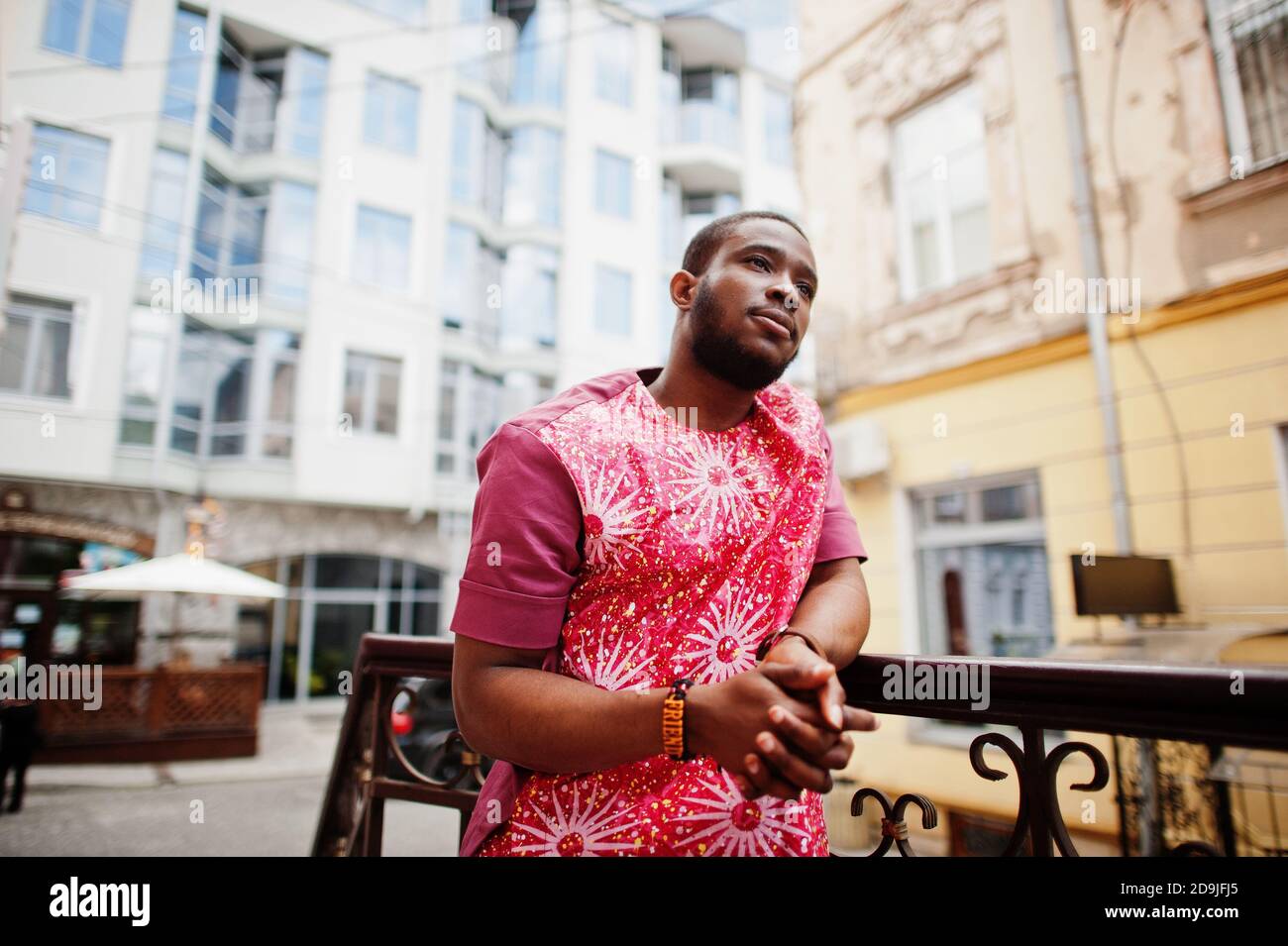 Portrait of a black young man wearing african traditional red colorful ...