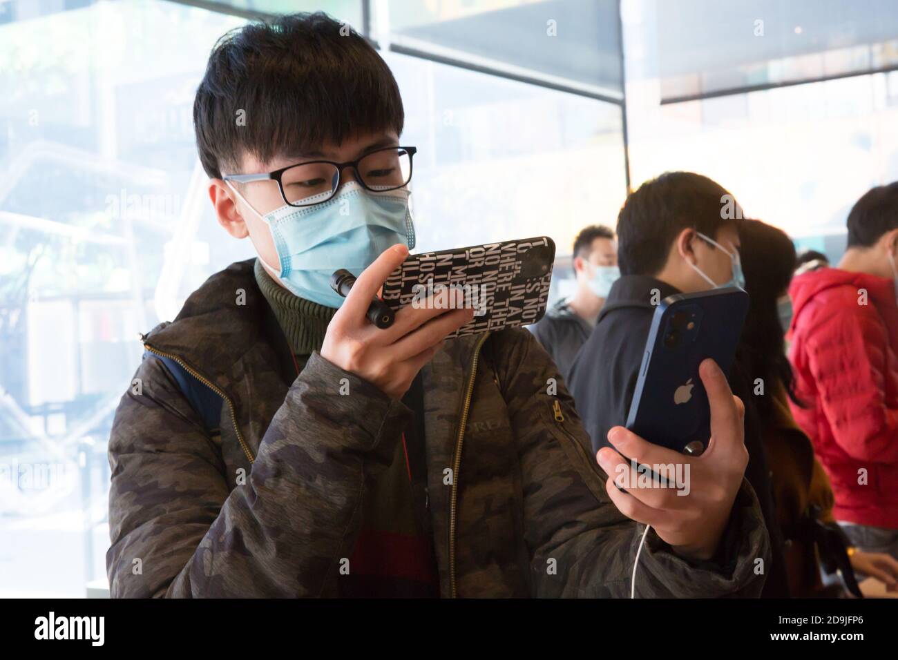 Customers experience the newly released iPhone 12 series at an Apple ...