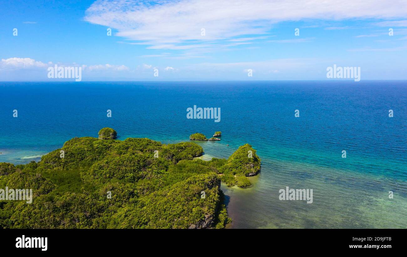 Aerial view of the mountains covered with jungle, blue sea and sky with ...