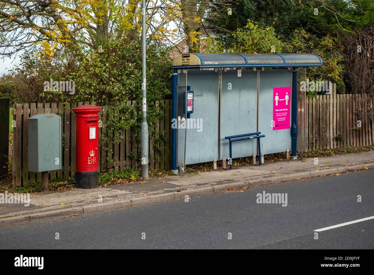 empty bus stop with seat and post box Stock Photo - Alamy