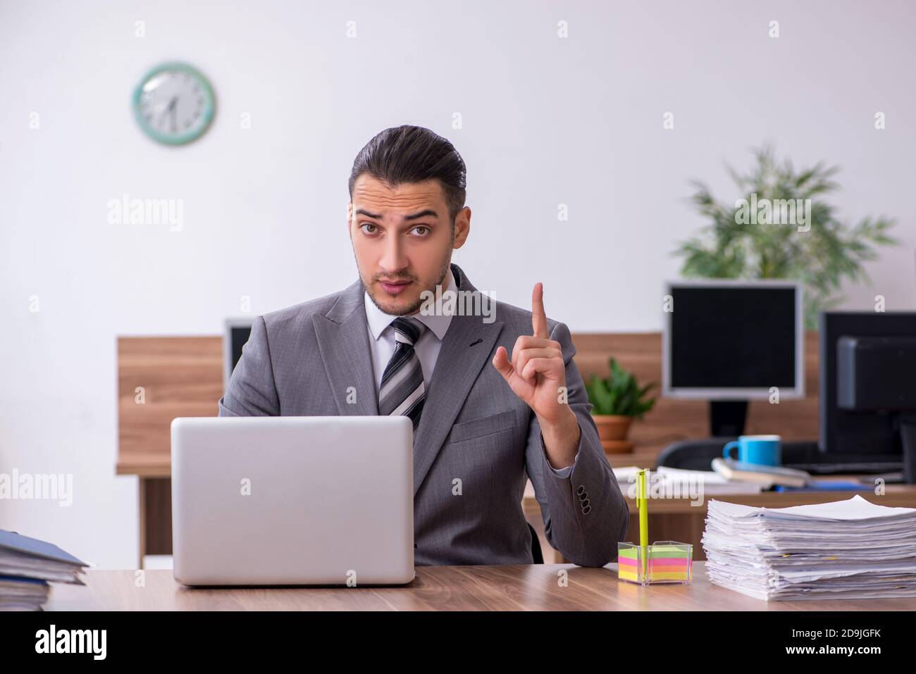 Young male employee working in the office environment Stock Photo - Alamy
